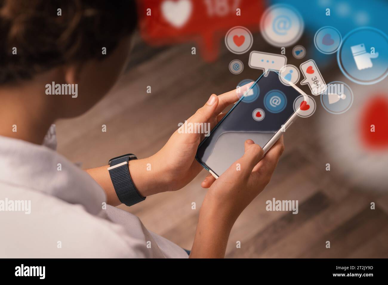 A young boy, seen from behind, uses his smartphone. Graphically ...