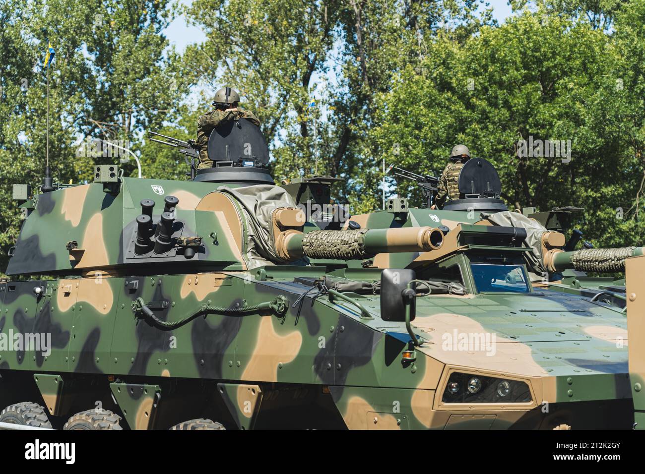 Military forces concept. Two smaller battle tanks with soldiers on top ...