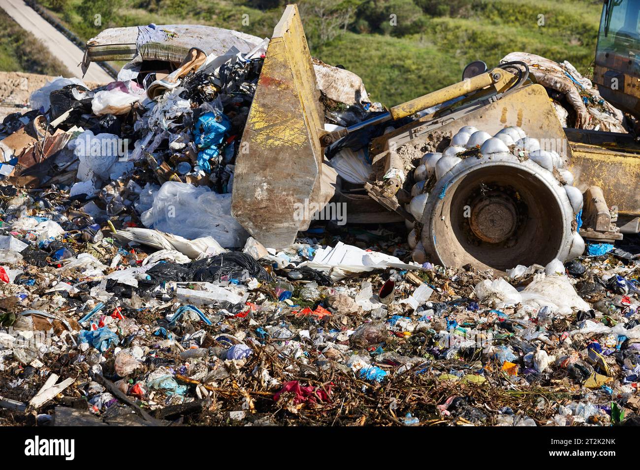 Heavy machinery shredding garbage in an open air landfill. Waste Stock ...