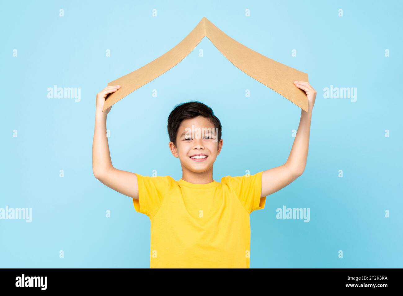 Cute smiling Asian mixed race boy holding paper above his head as a ...