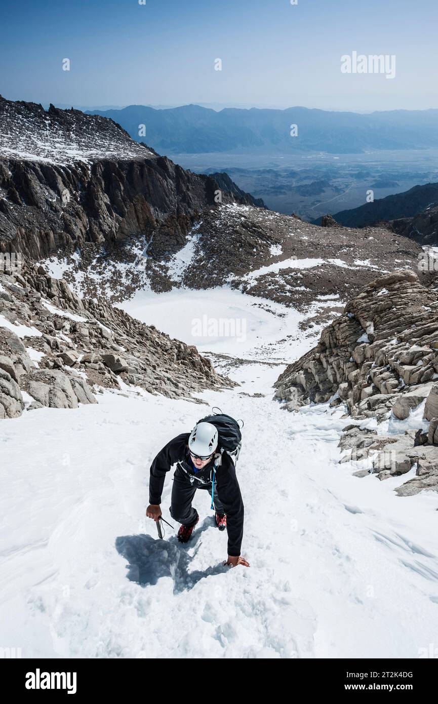 Hiker Ascending snowy chute on Mountaineers Route of Mount Whitney ...