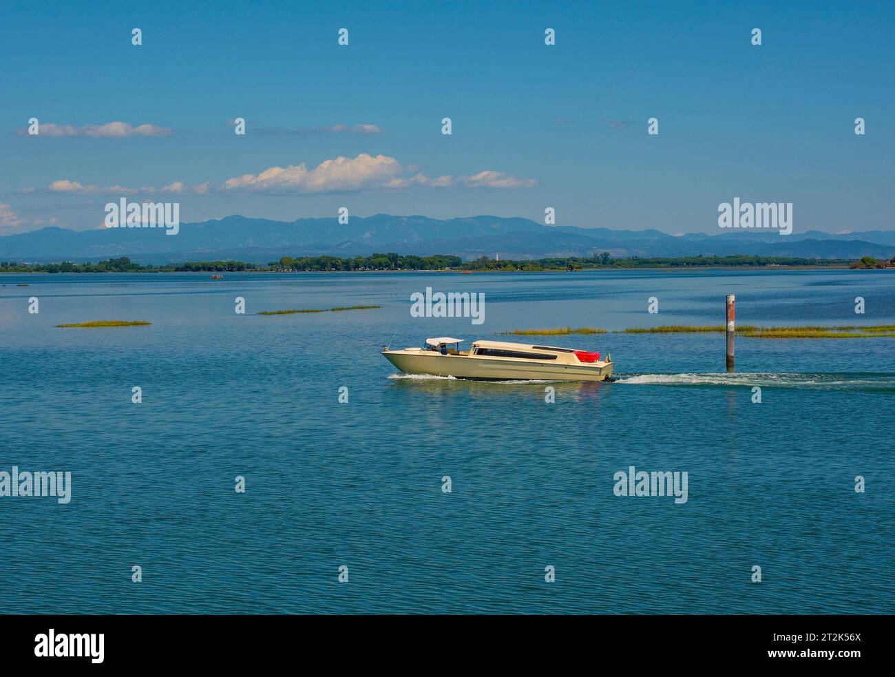 A water taxi crosses the shallow waters of the Grado section of the ...
