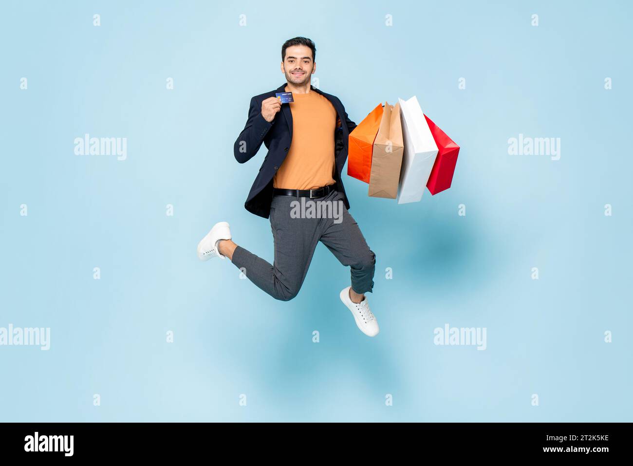 Portrait of young smiling Caucasian man holding shopping bags and ...
