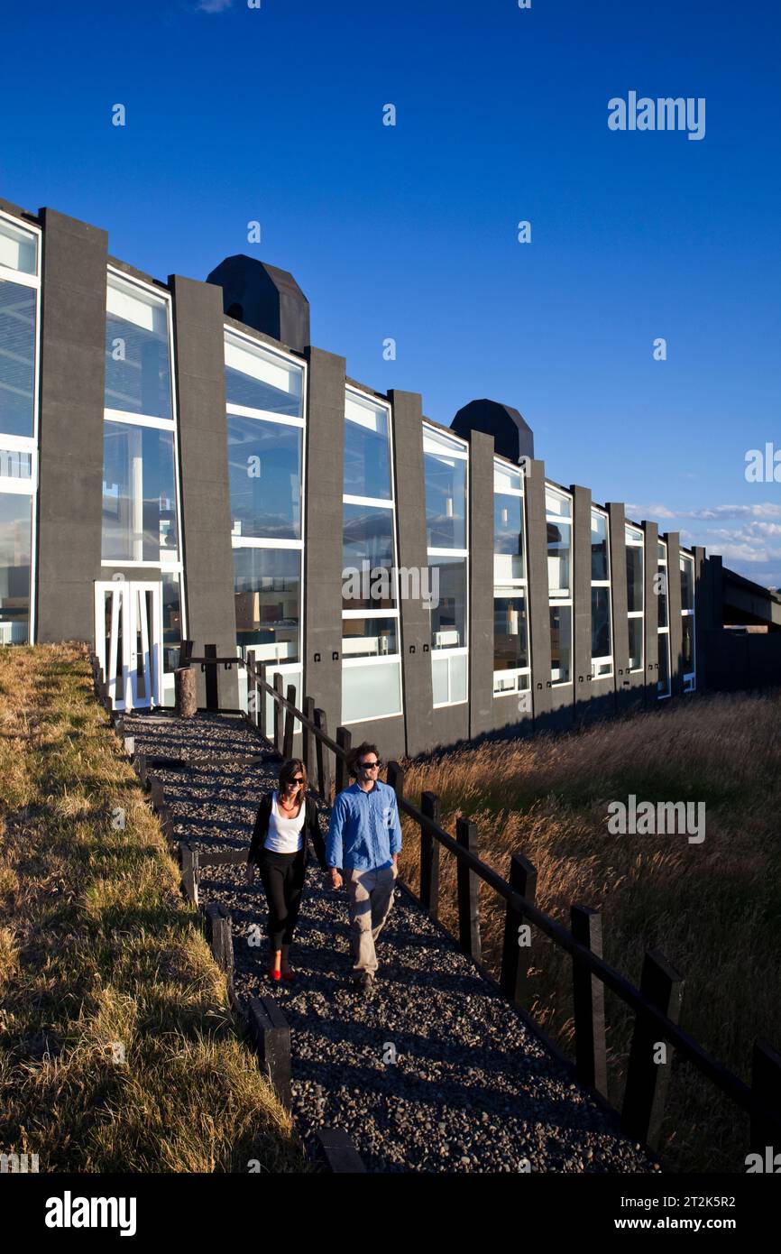 A couple walks down a pathway at a fancy hotel on a sunny evening Stock ...