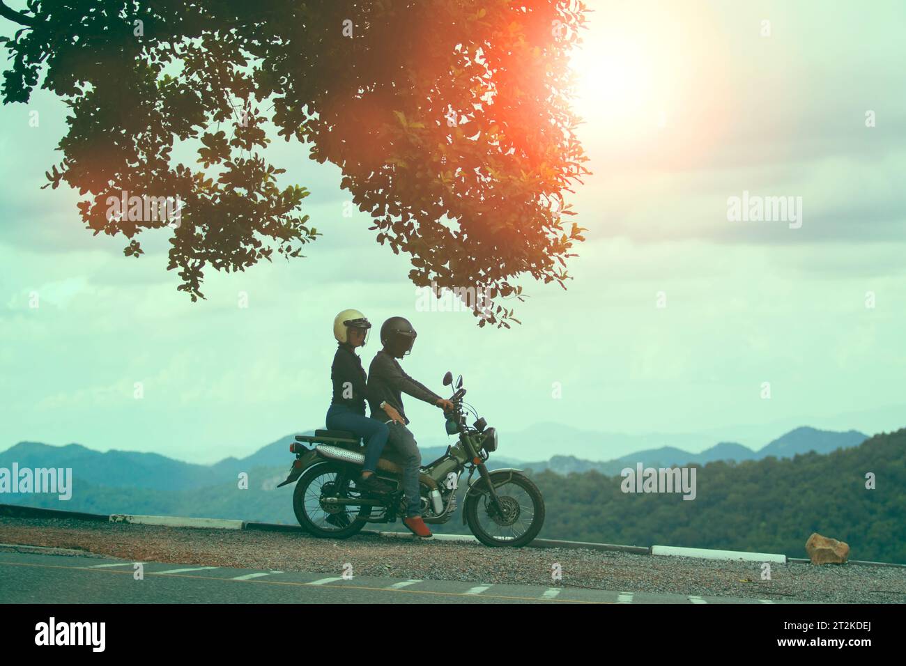 couples wearing safety helmet sitting on small enduro motorcycle ...