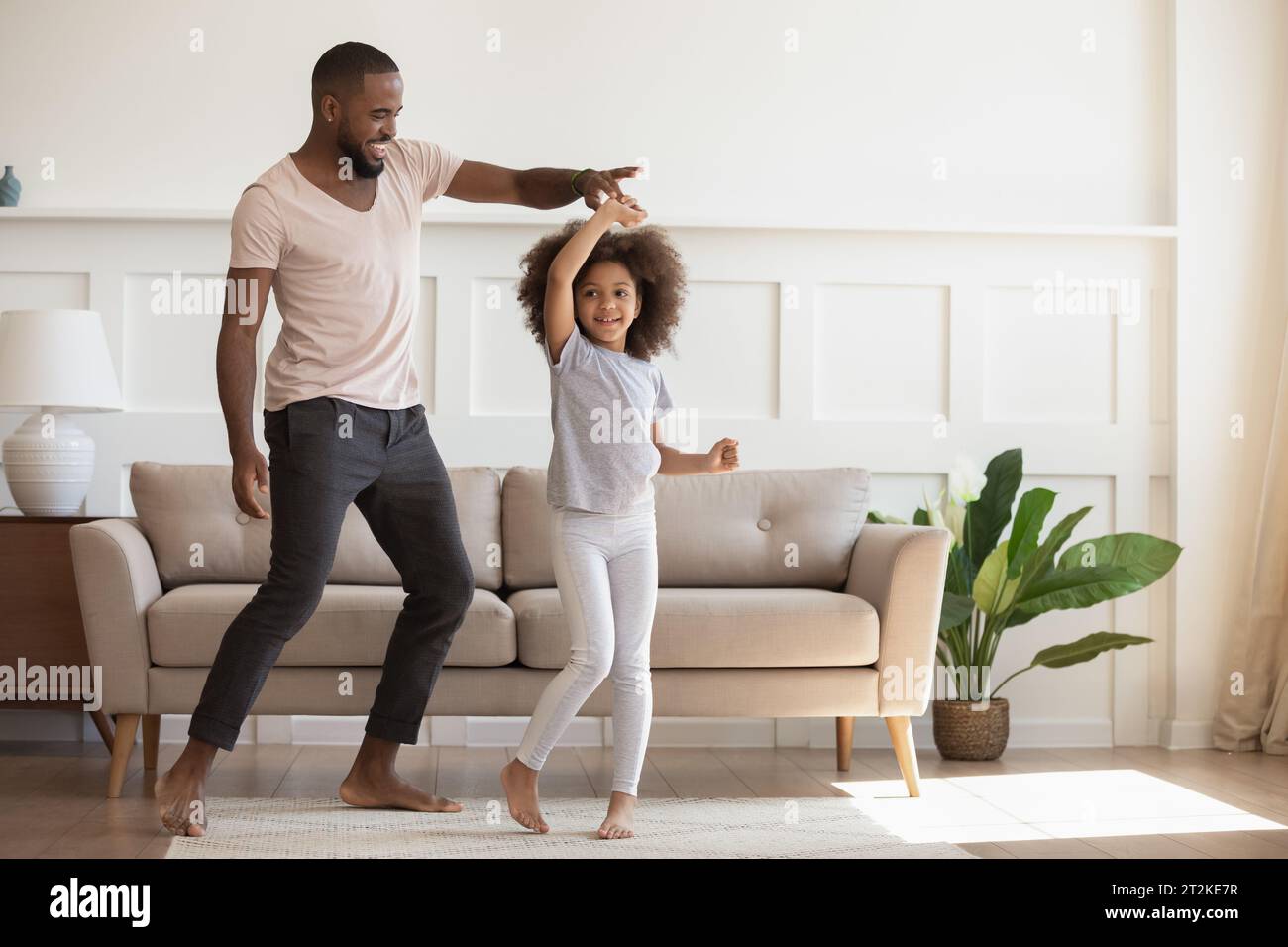 Excited loving african american smiling father twisting cute little daughter Stock Photo - Alamy