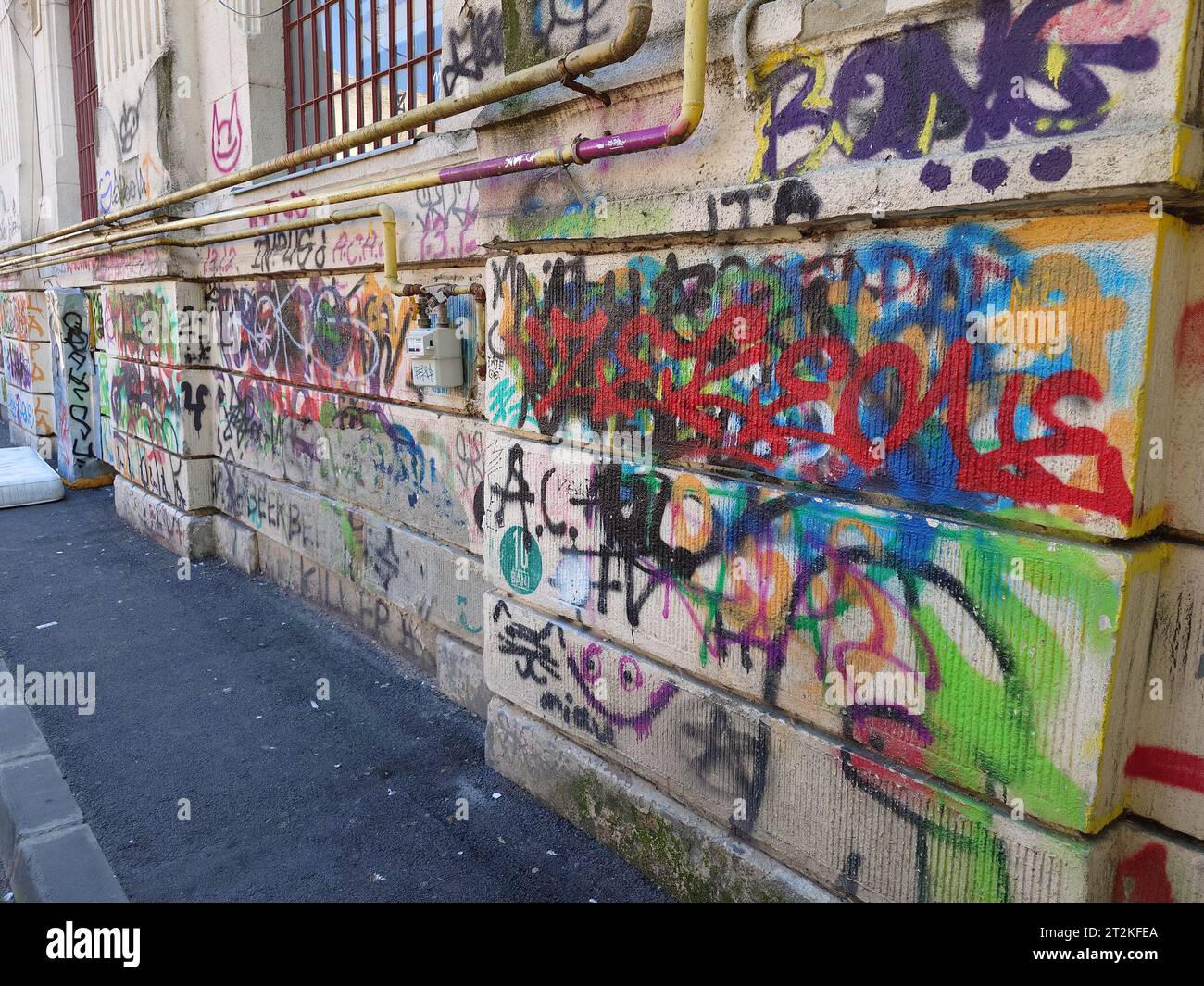 Urban backstreet building walls or facade covered in colorful graffiti ...