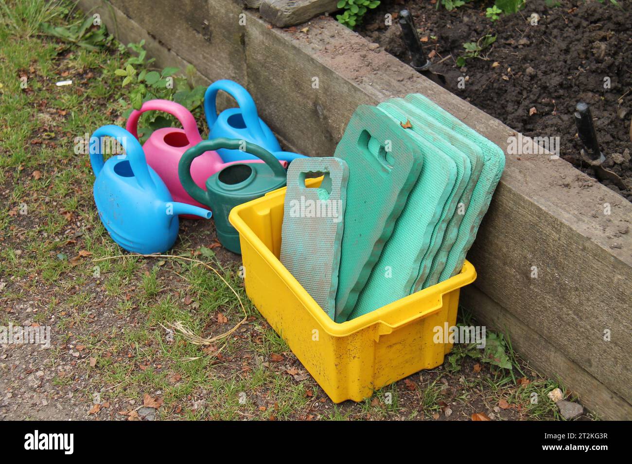 Plastic Kneeling Pads and Watering Cans for Gardening Stock Photo - Alamy