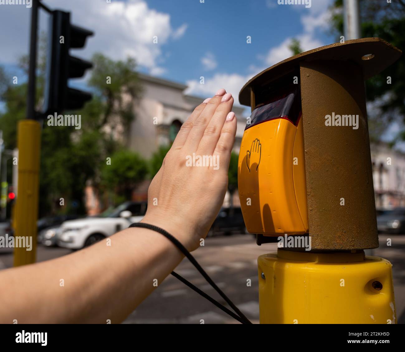 Close-up of a blind woman's hand pressing a button for a traffic light ...
