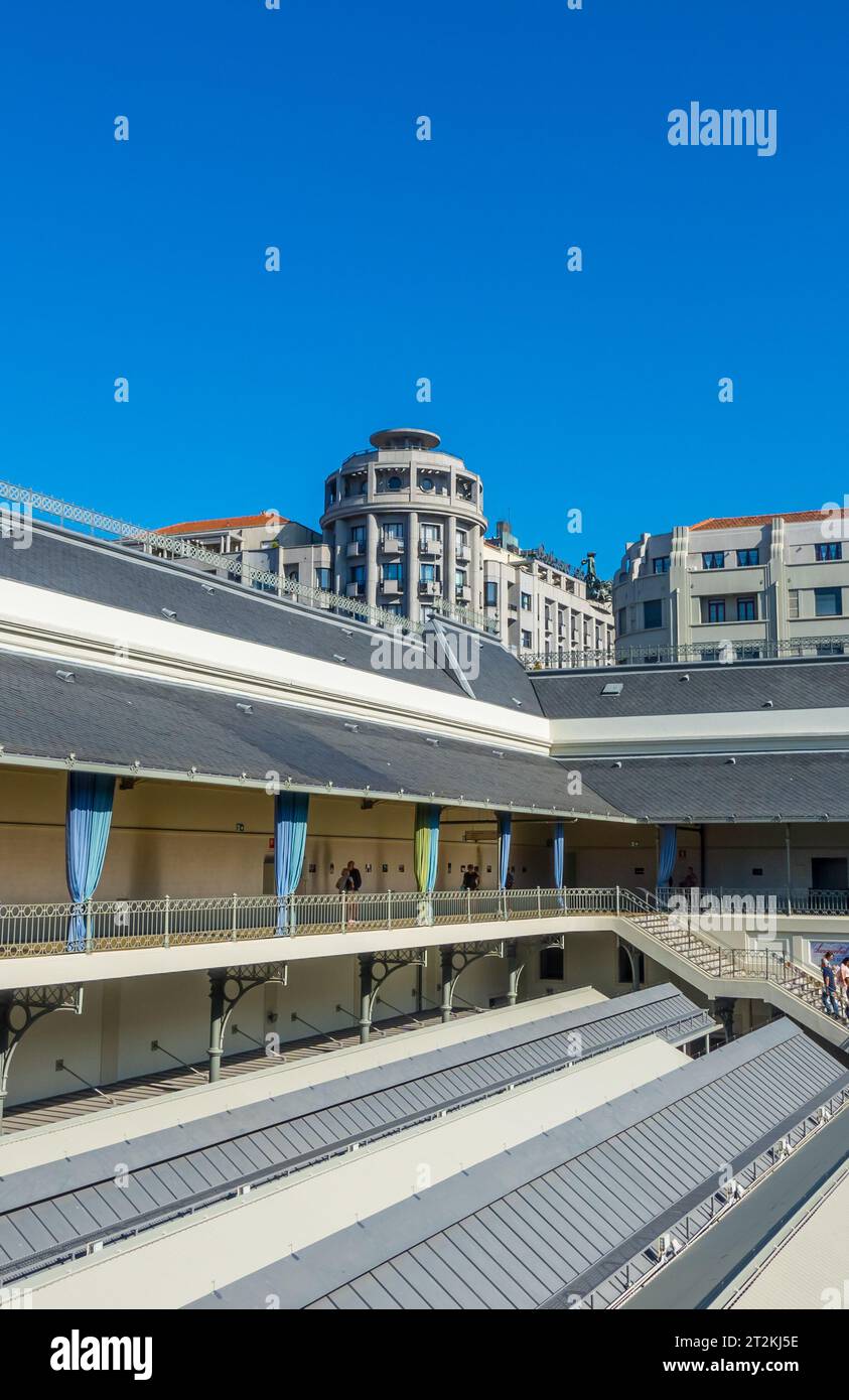 An elevated train passes by two large buildings situated side by side ...
