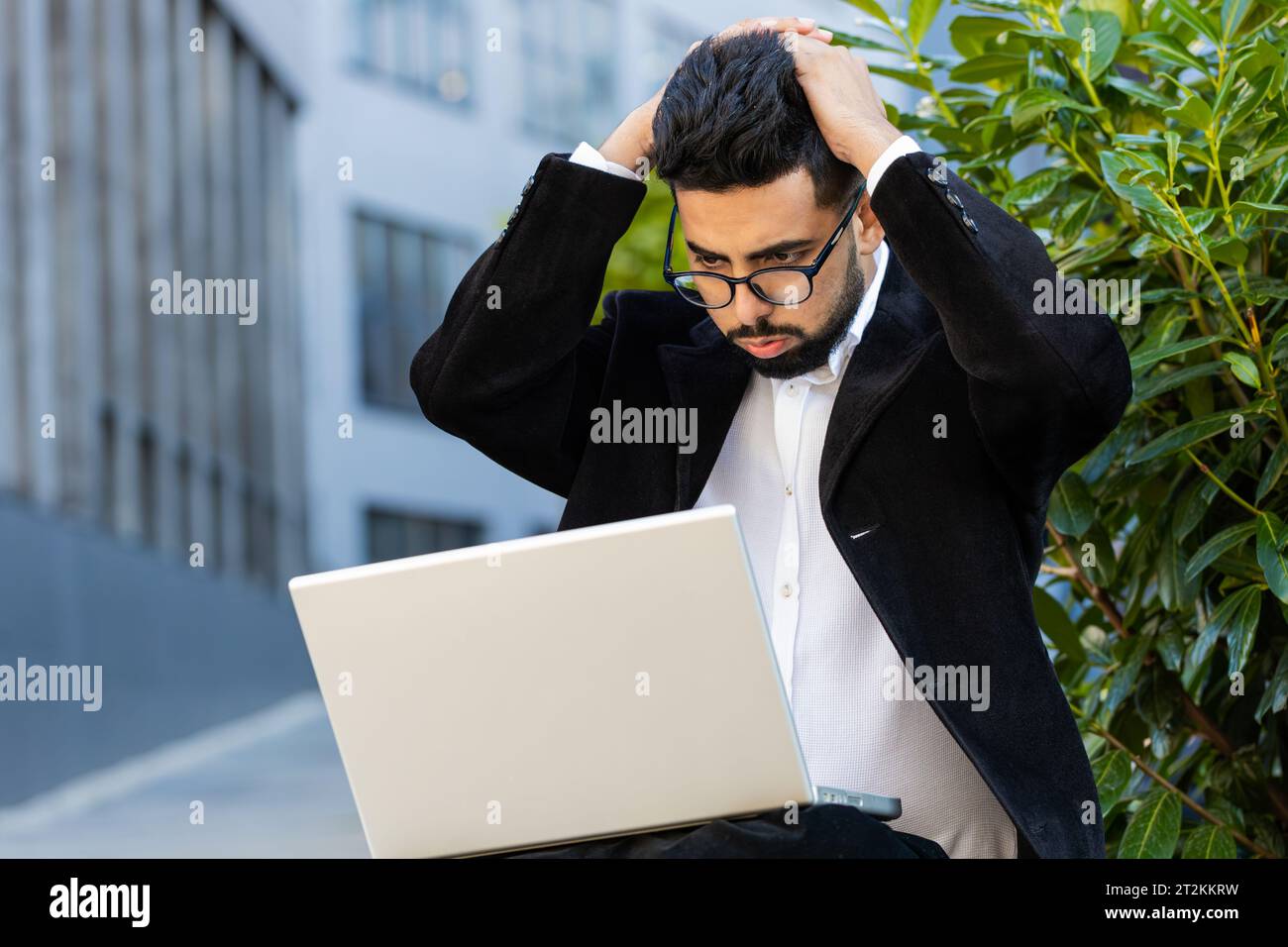 Displeased worried Indian businessman use laptop notebook typing ...