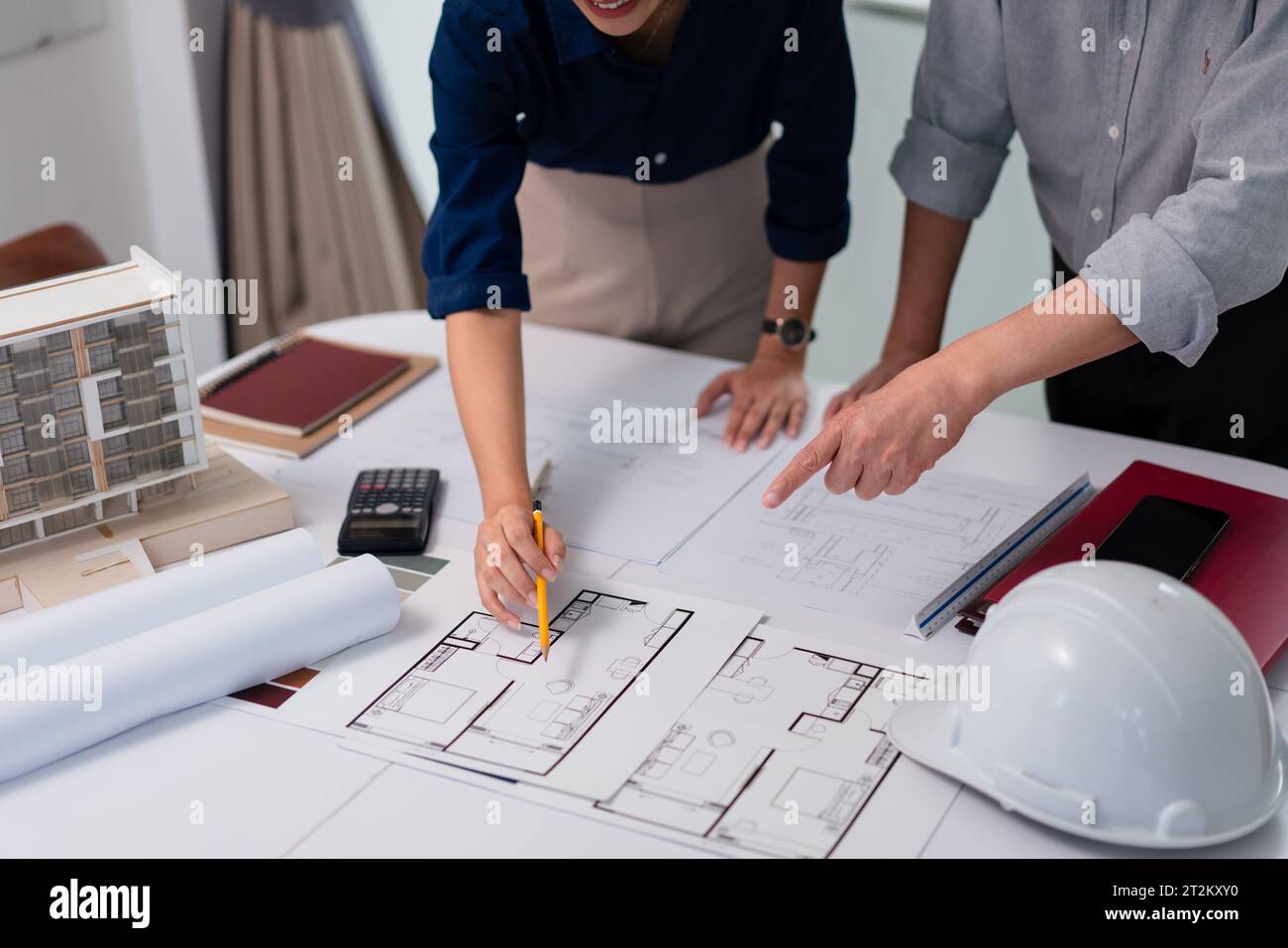 Two Architects Pointing On Blueprint To Discuss And Planning About Construction Building Project