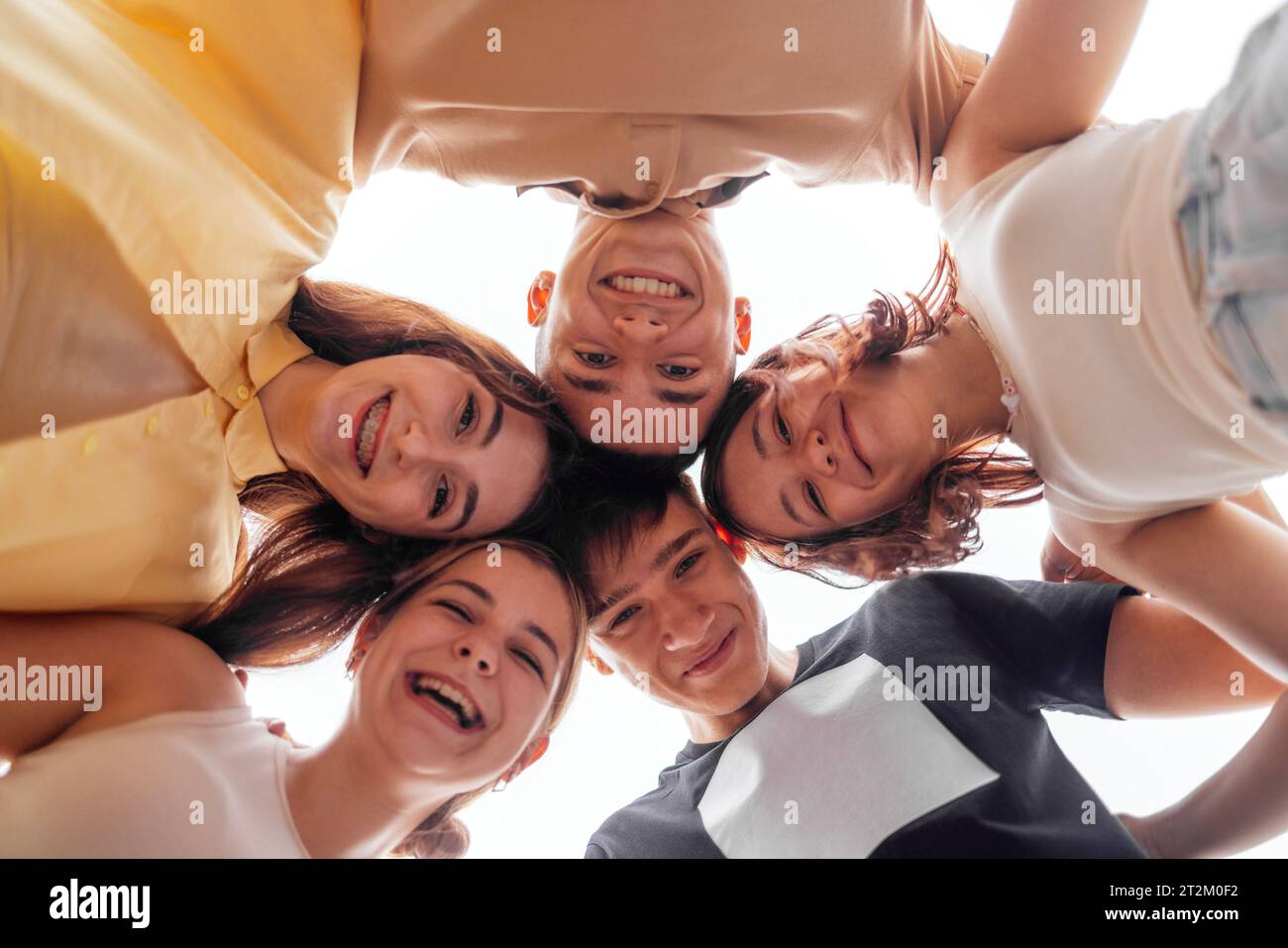 Funny smiling teenagers standing and looking down at camera. Group of ...