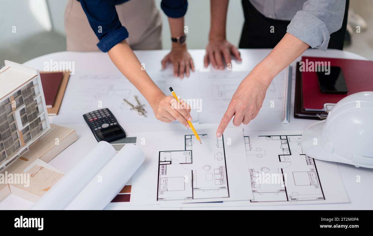 Two architects pointing on blueprint to discuss and planning about ...