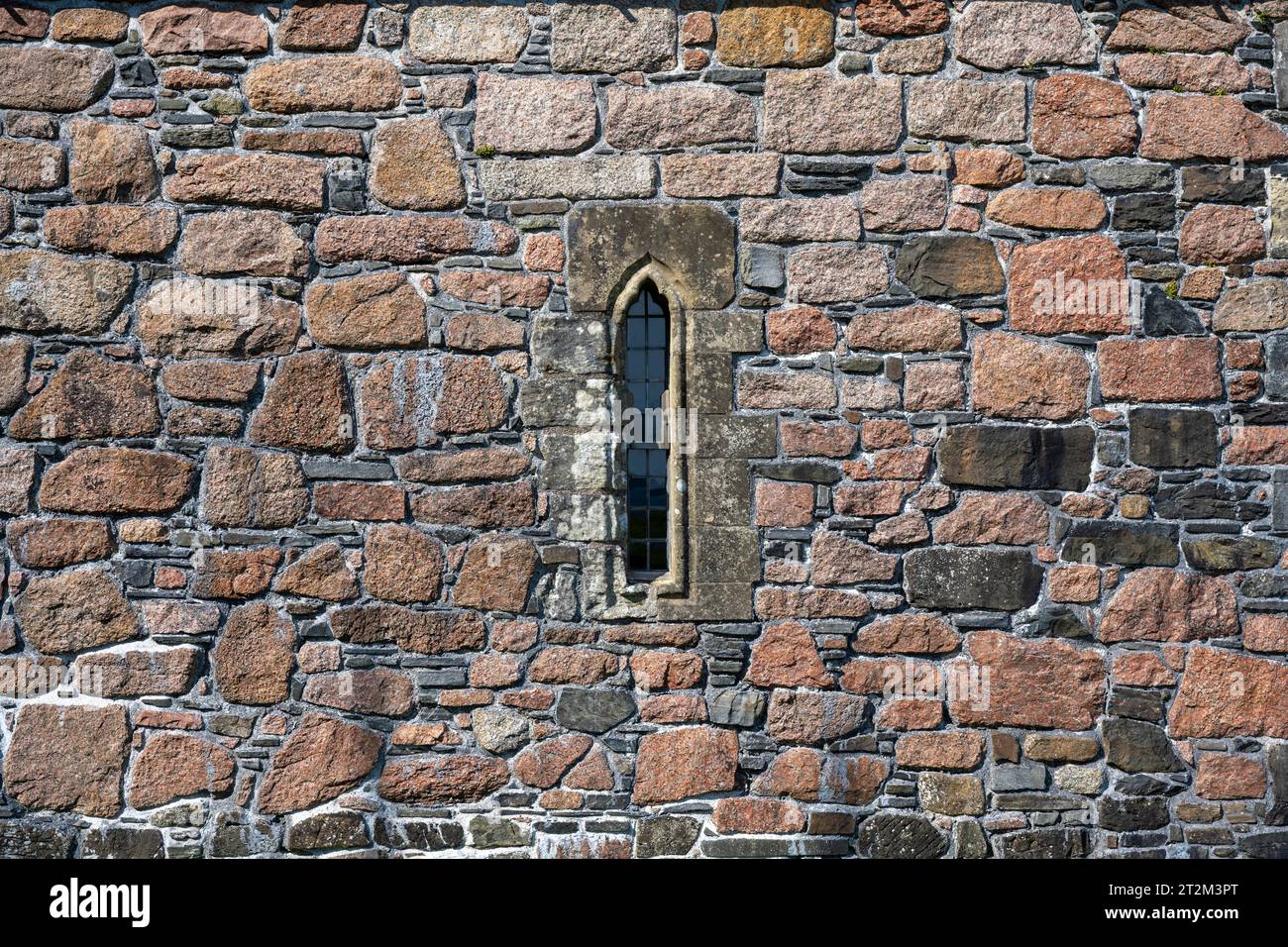 Ross of Mull granite and basalt house wall with a narrow window, full ...