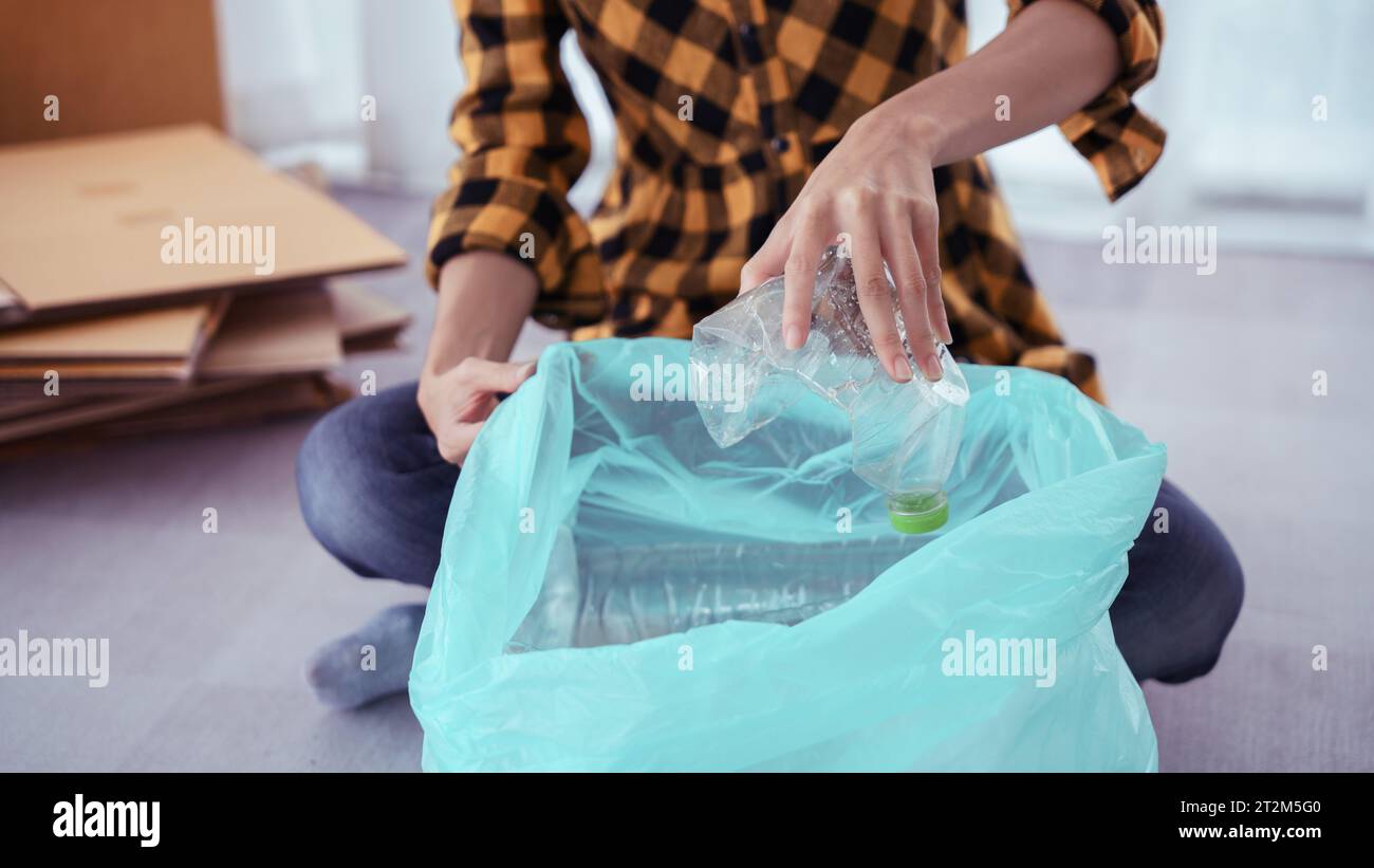 Women squeeze plastic bottle and putting in plastic bag for recycling ...