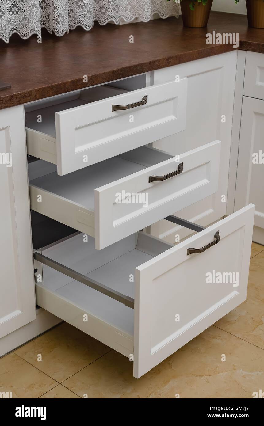 White drawers in the kitchen set. Open furniture drawers Stock Photo ...