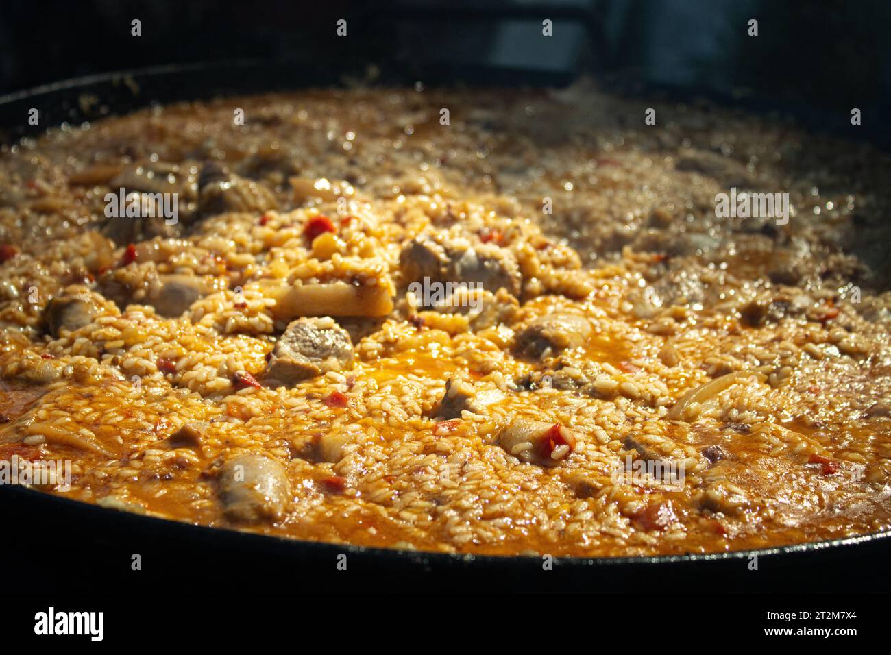A large paella cooking over fire with a smokey background Stock Photo ...