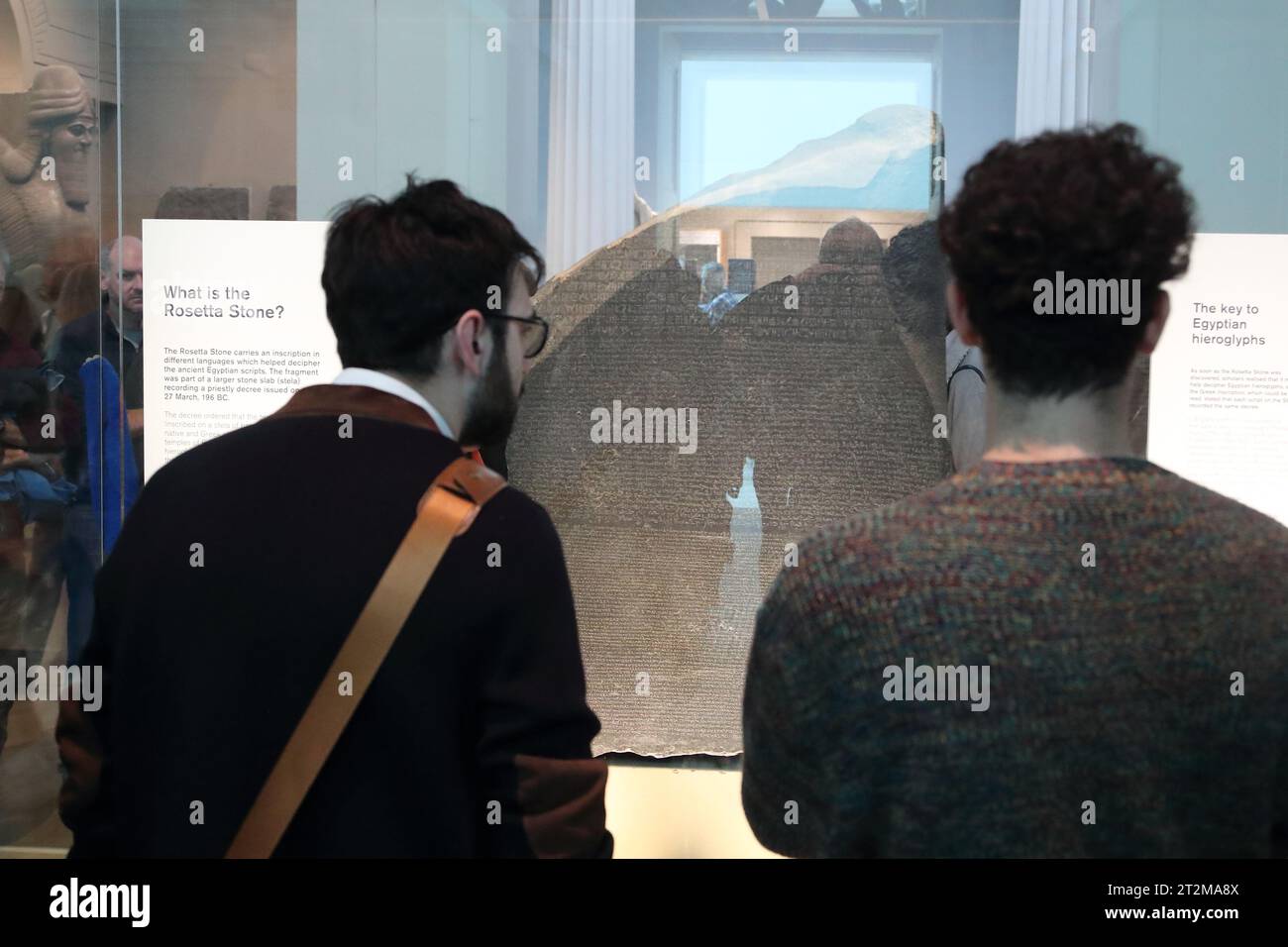 Visitors study the Rosetta Stone at the British Museum, London, UK ...