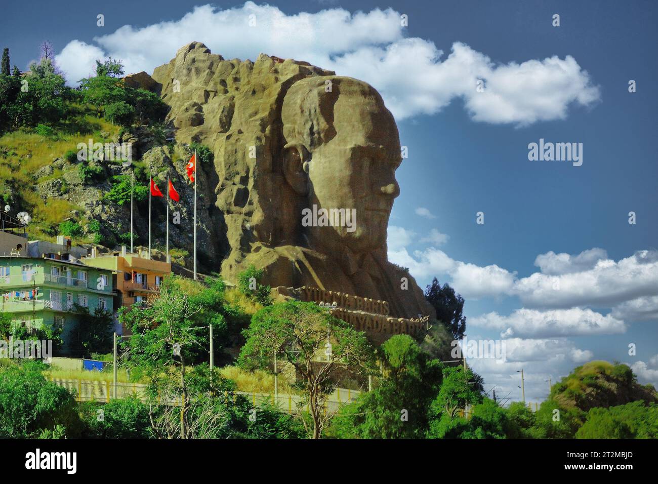 A colossal stone statue perched atop a hill covered in a blanket of ...