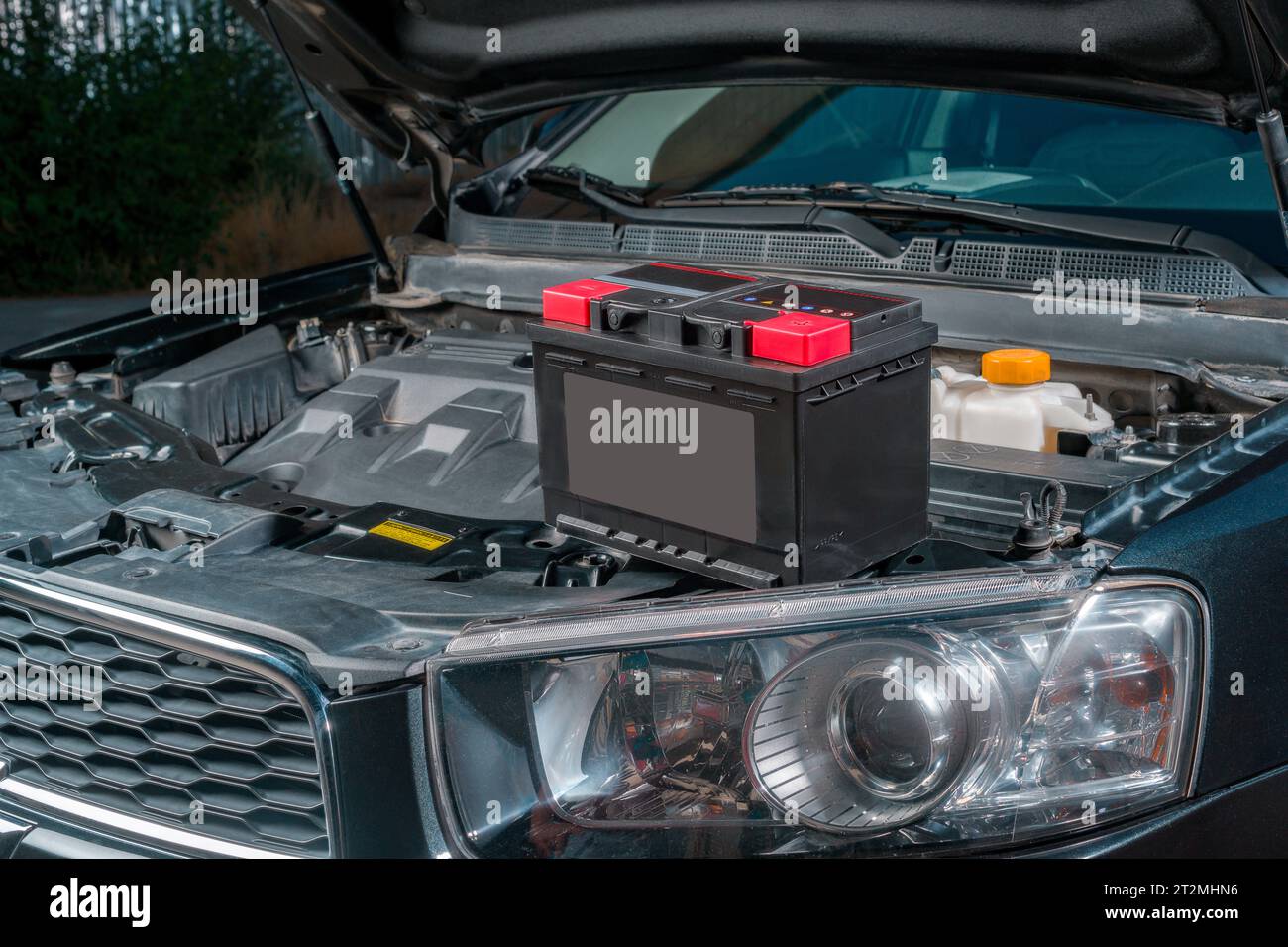 A new battery sits on the engine of a car with the hood open Stock ...