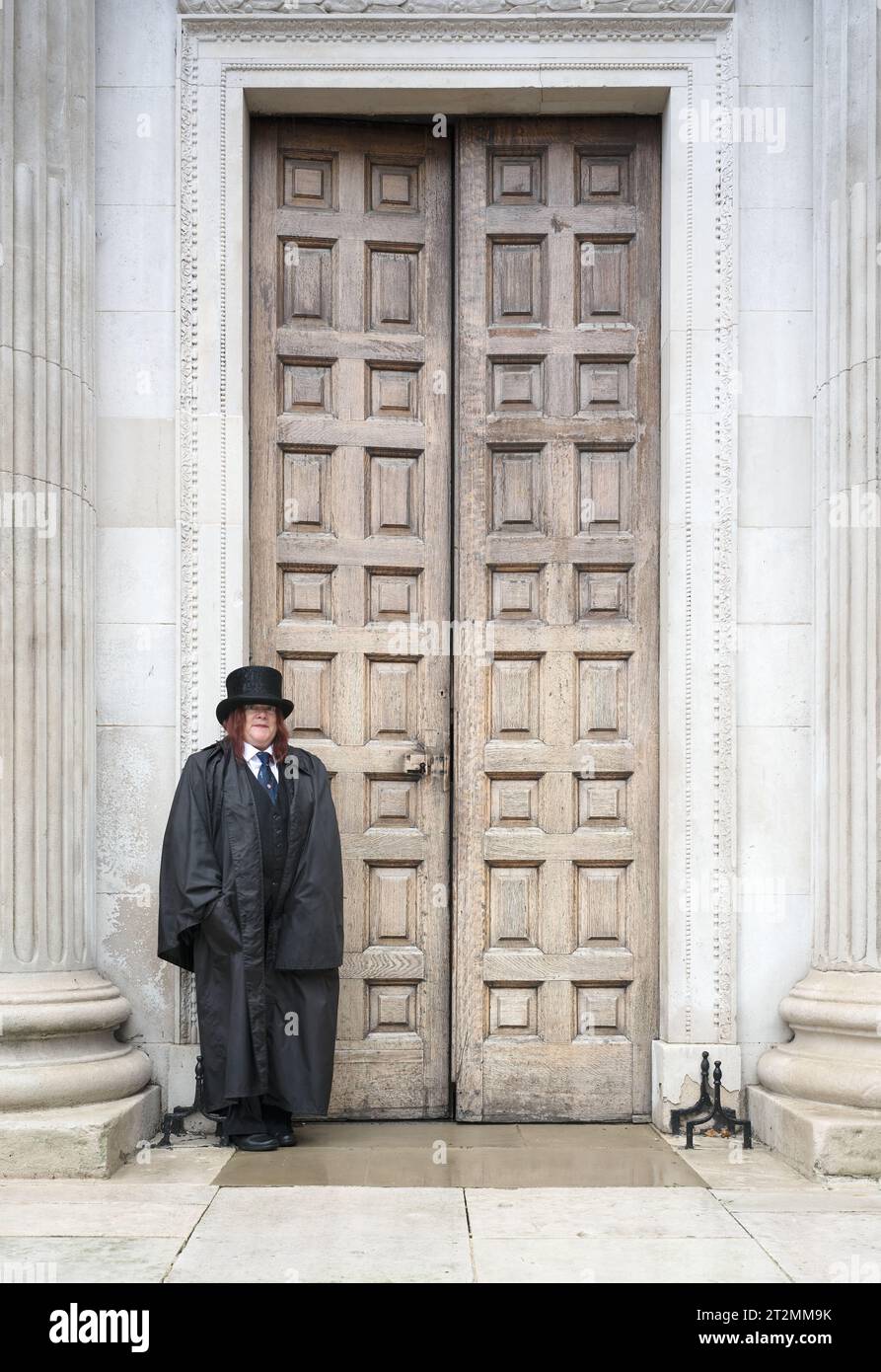 A rainy day for a female guard in a top hat at the high door entrance ...
