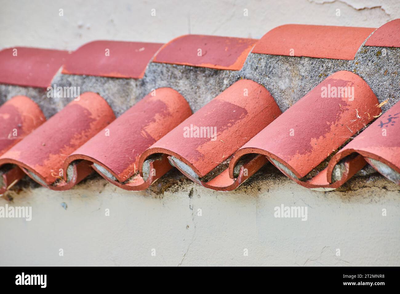 Interconnected reddish orange roof shingles close up with bits of ...