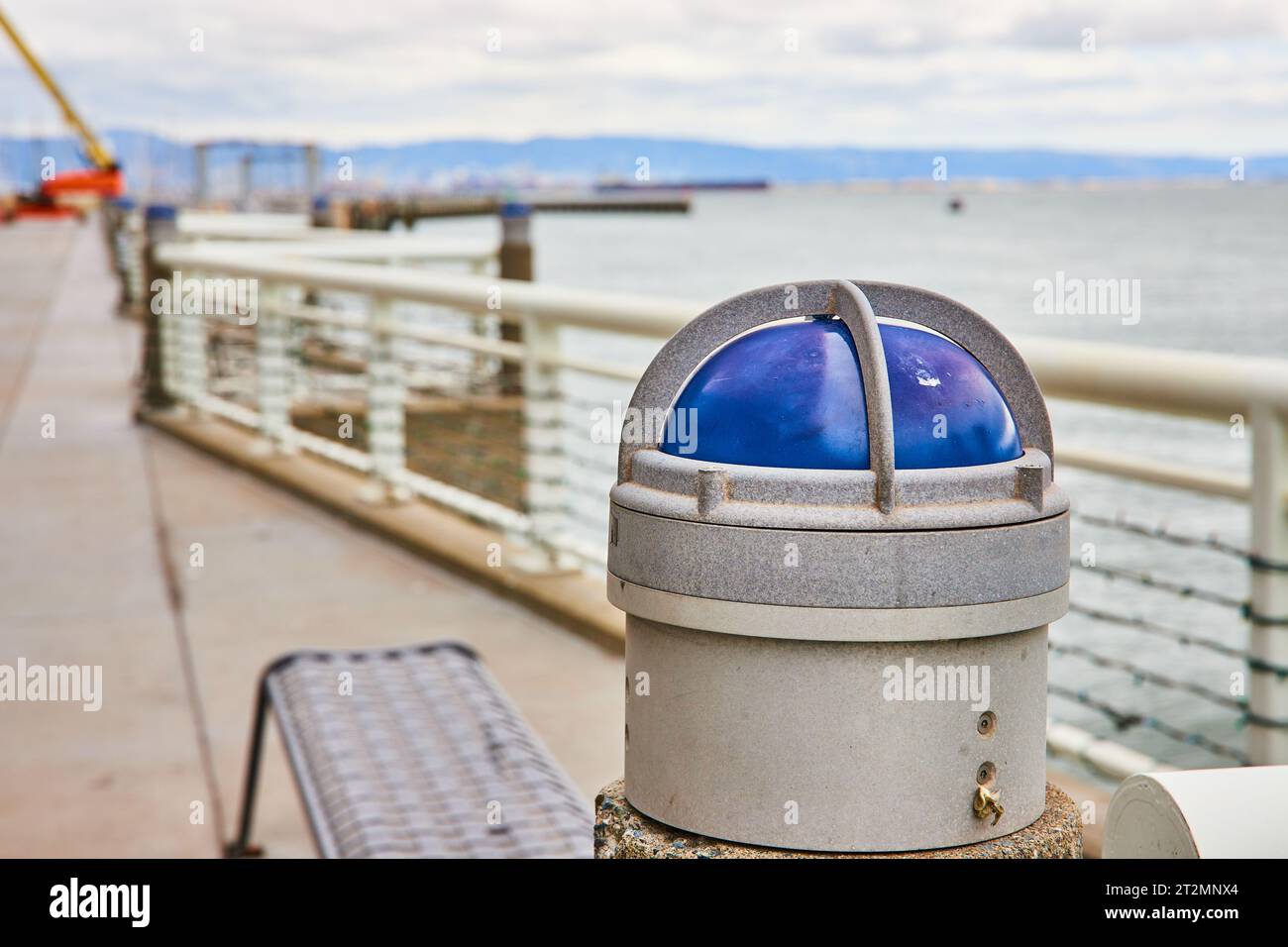 Blue light on heavy duty harbor railing with blurry background of San ...
