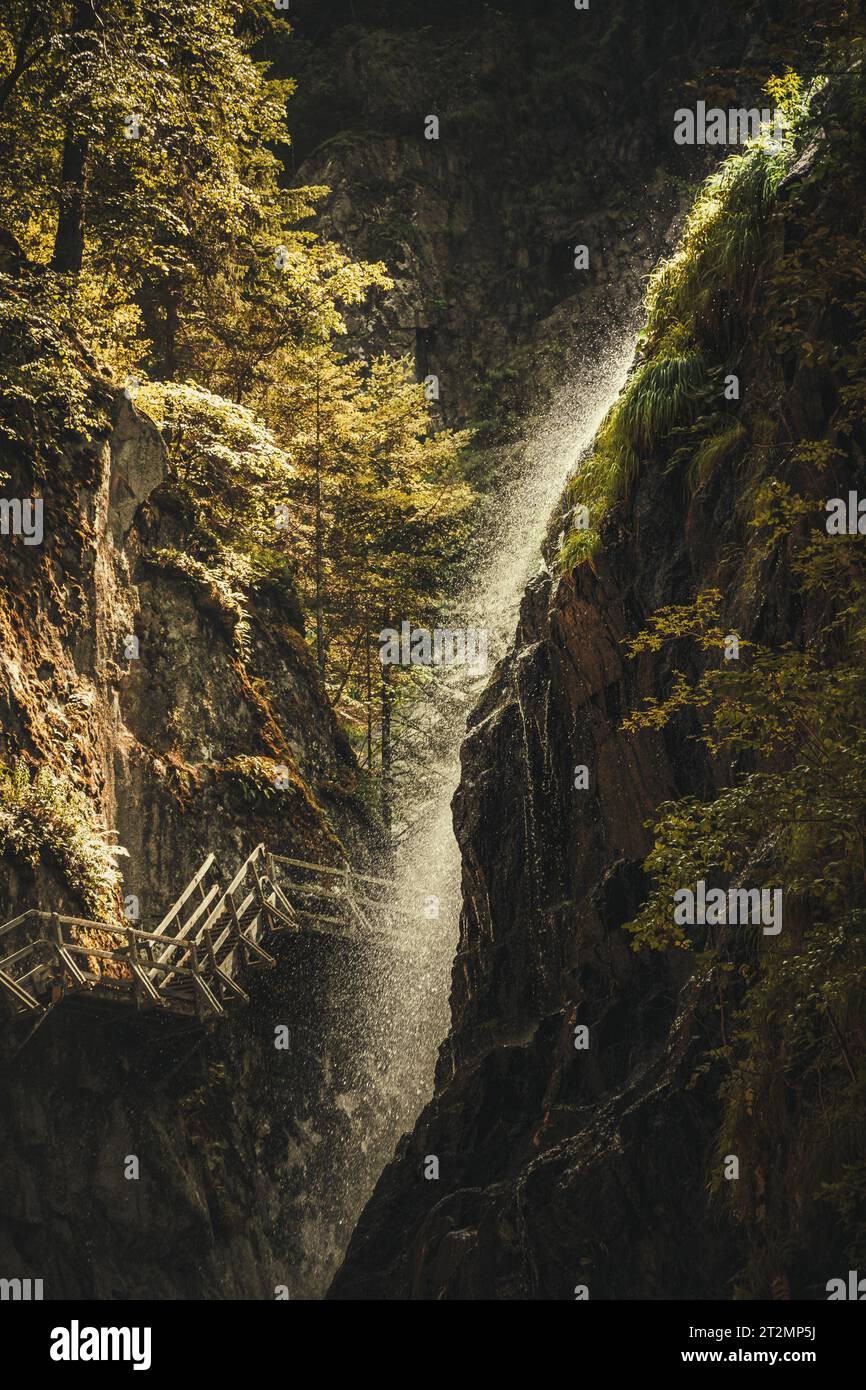 Landscape view of a waterfall in a gorge illuminated by the summer sun ...