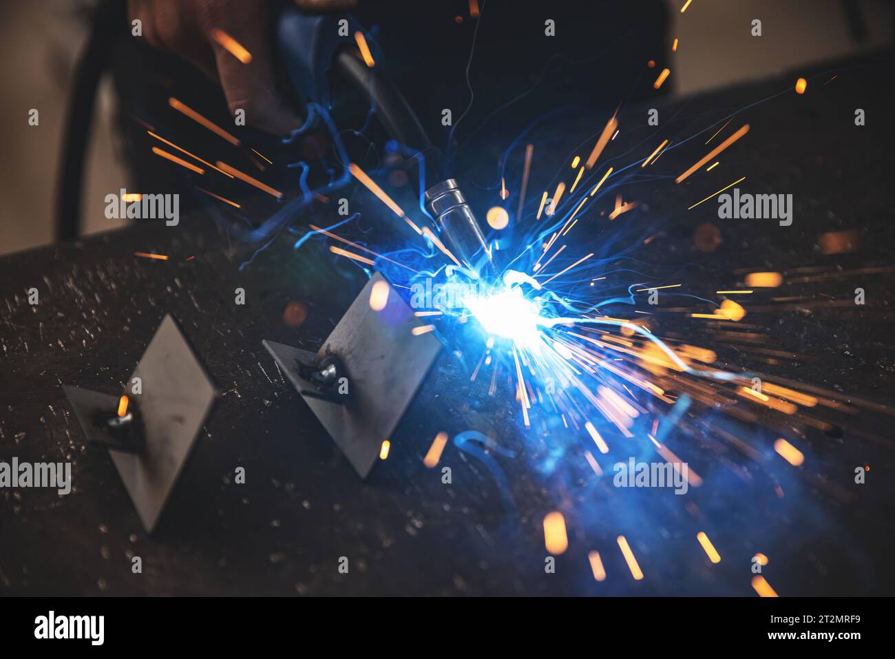 Male worker hand welding steel rack, close up. Sparks in metalworking ...