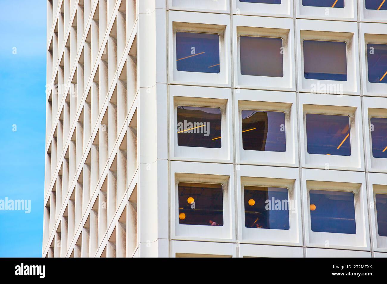 Square windows on skyscraper zoomed in view on bright blue sky day with ...