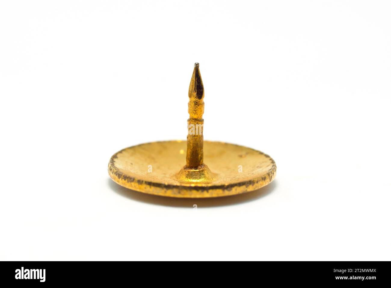 Close Up Of A Single Brass Drawing Pin Push Pin Or Thumb Tack Isolated Against A White