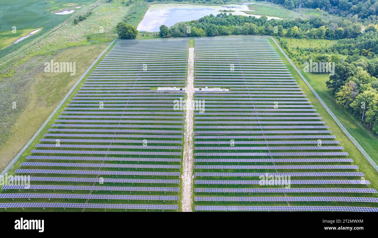Rows of solar panels in solar field aerial with swamp land in distance ...