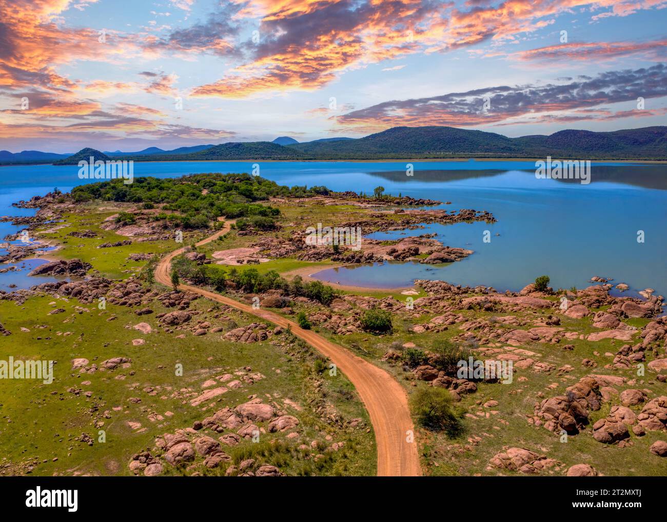 aerial view of Gaborone dam, road to the island, in Botswana at sunset ...