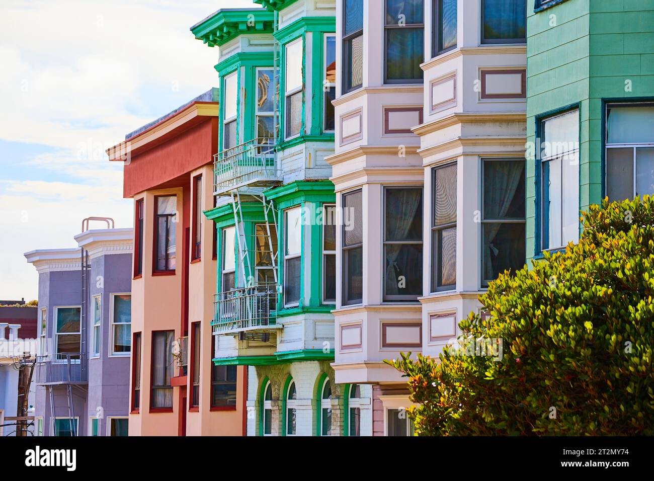 Pastel colored apartment buildings with wide array of bay windows side ...