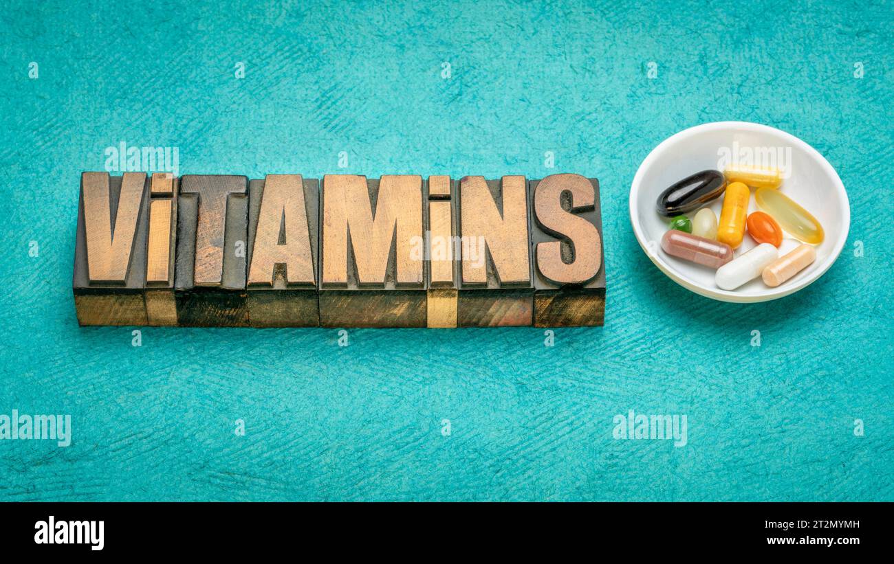 vitamins word in vintage letterpress wood type with a small bowl of ...