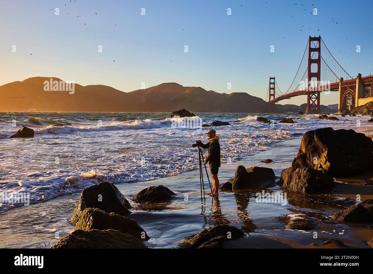 Barefoot photographer capturing sunset on San Francisco Marshalls Beach ...