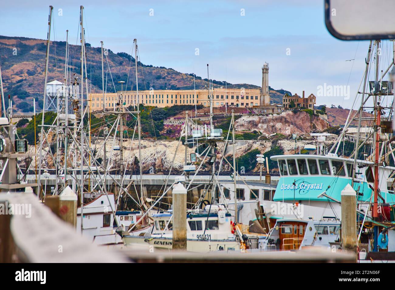 View of Alcatraz prison building on top of hill seen through ship masts ...
