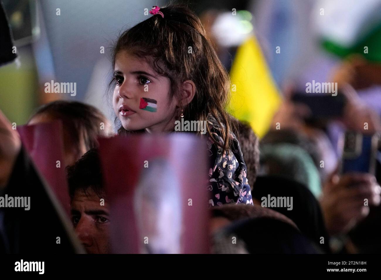 With the Palestinian flag painted on her face, a young girl attends a ...
