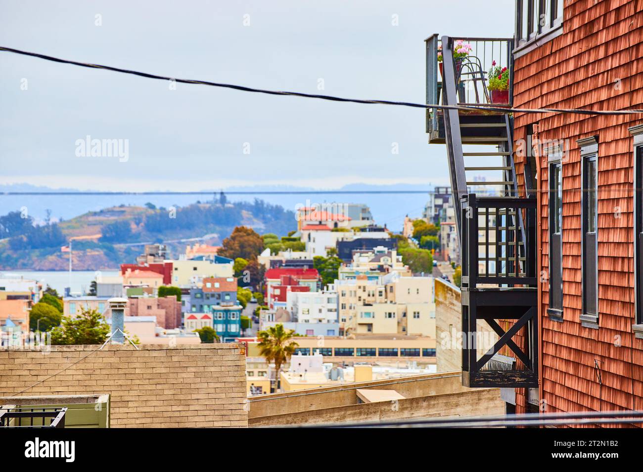 Side of reddish brown building with black stairs and patio overlooking ...