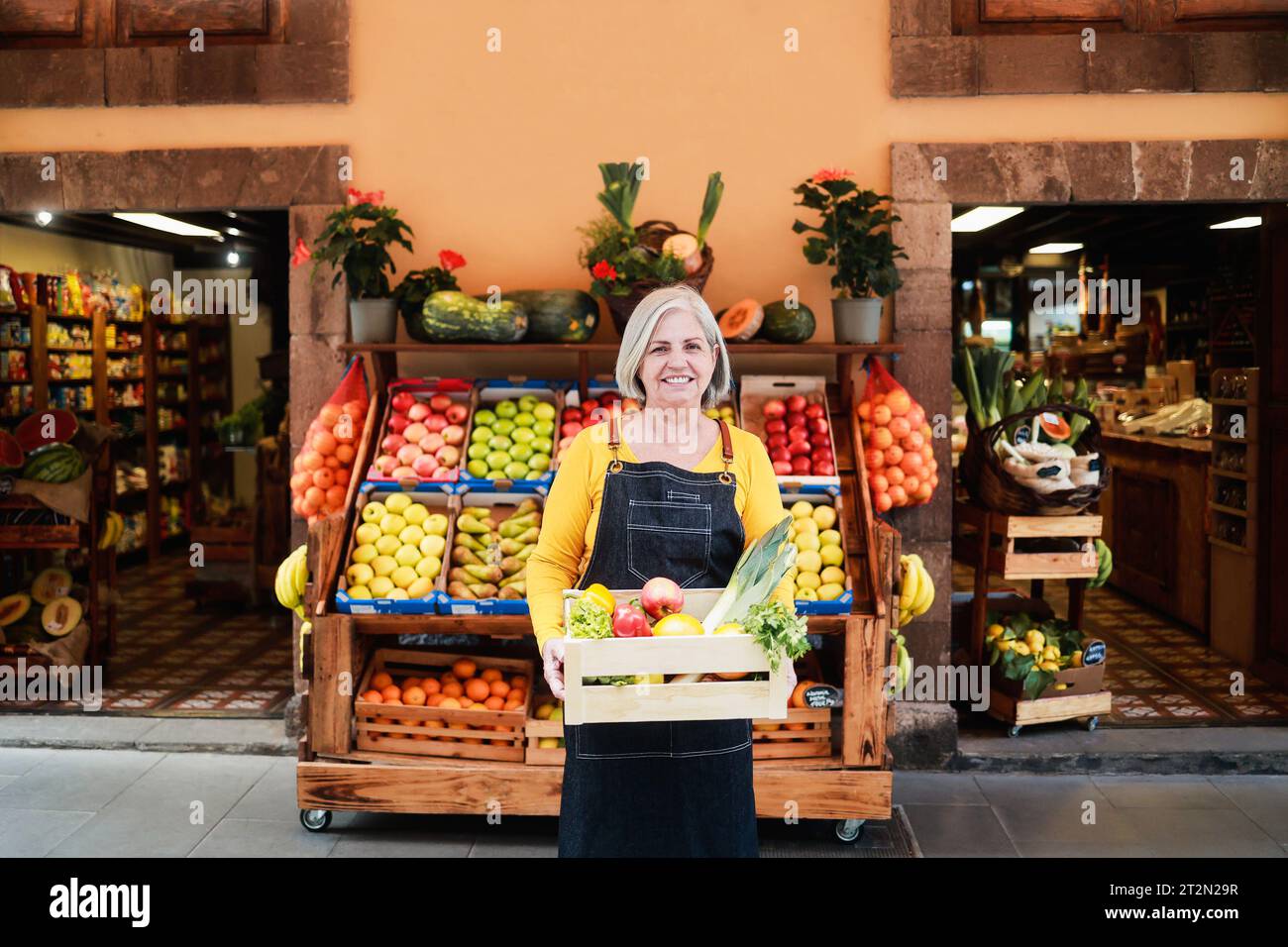 Senior woman working at grocery market food store - Worker selling ...