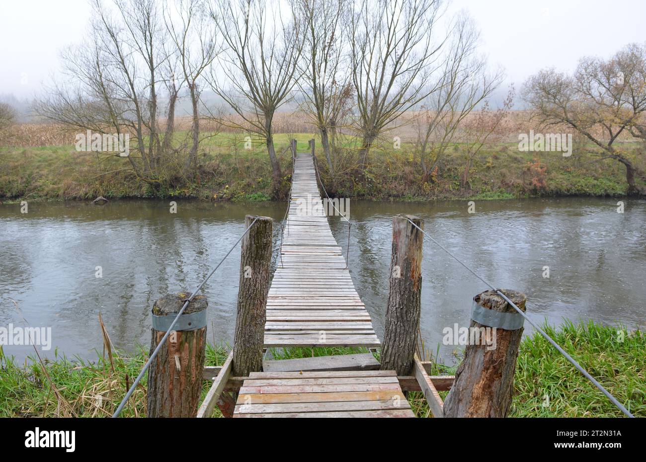 A wooden bridge across a small river Stock Photo - Alamy