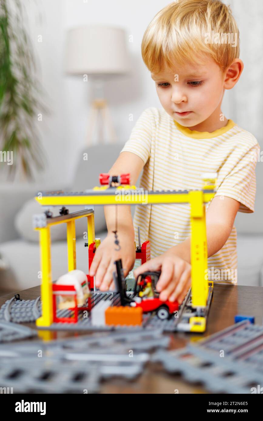 Child boy playing and building with colorful plastic bricks at the ...