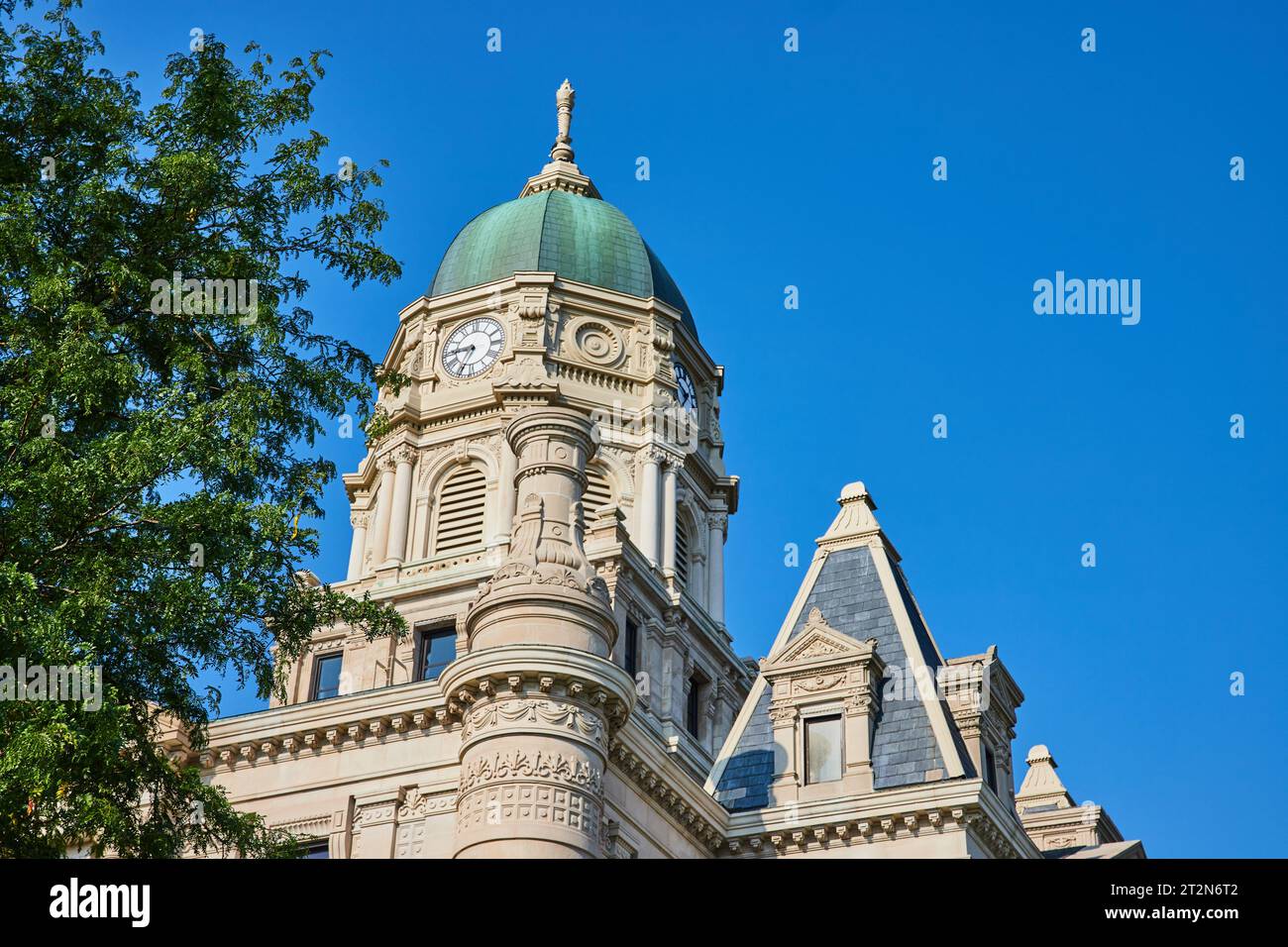 Shot of upper roof top view with blue sky behind it and clock tower on ...