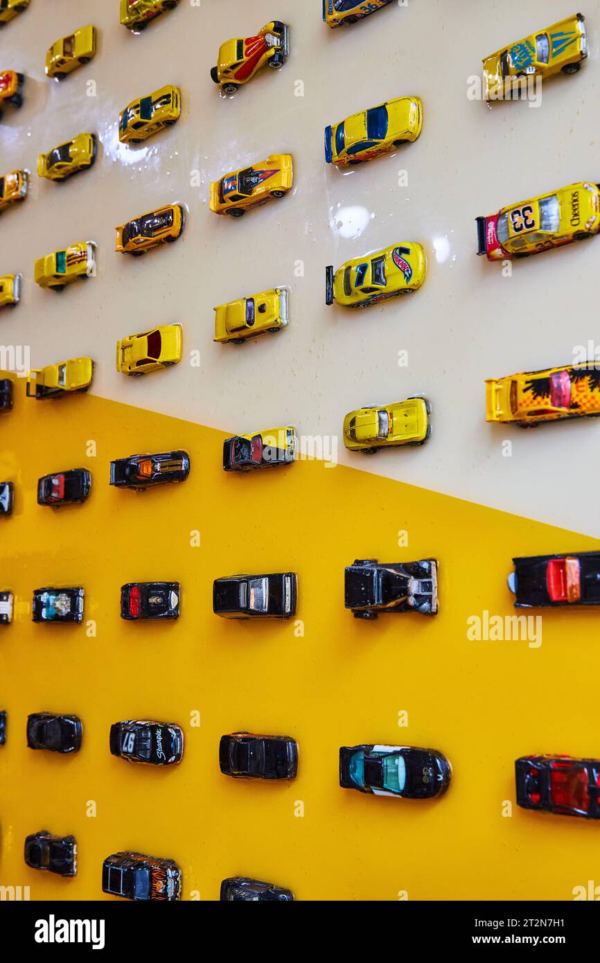 Black and yellow toy cars on shiny wall split diagonally between white ...