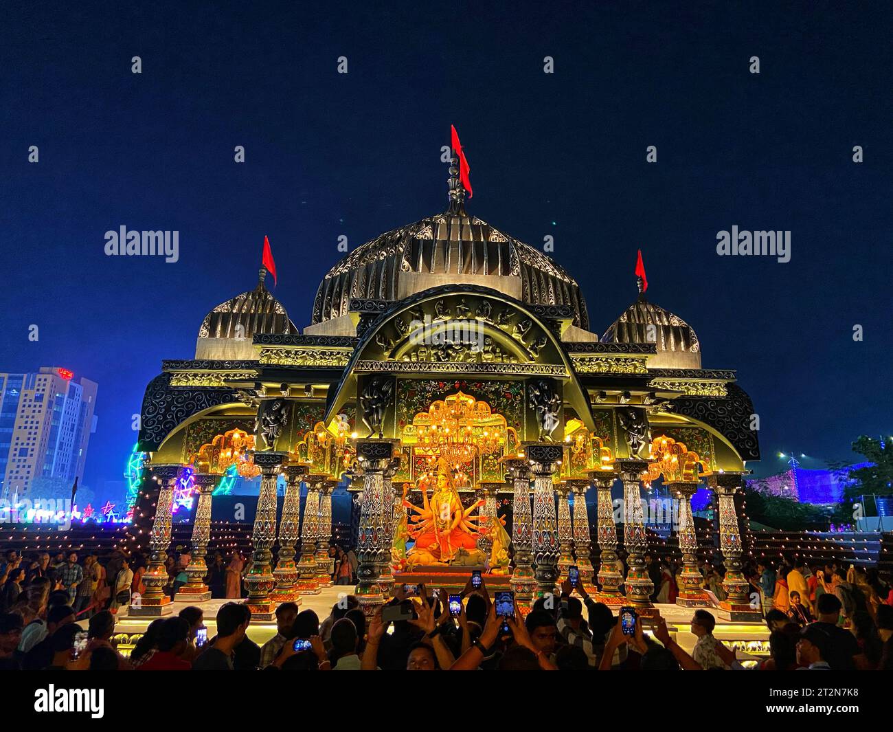 Visitors take photos of an idol of the Hindu Goddess Durga at the ...