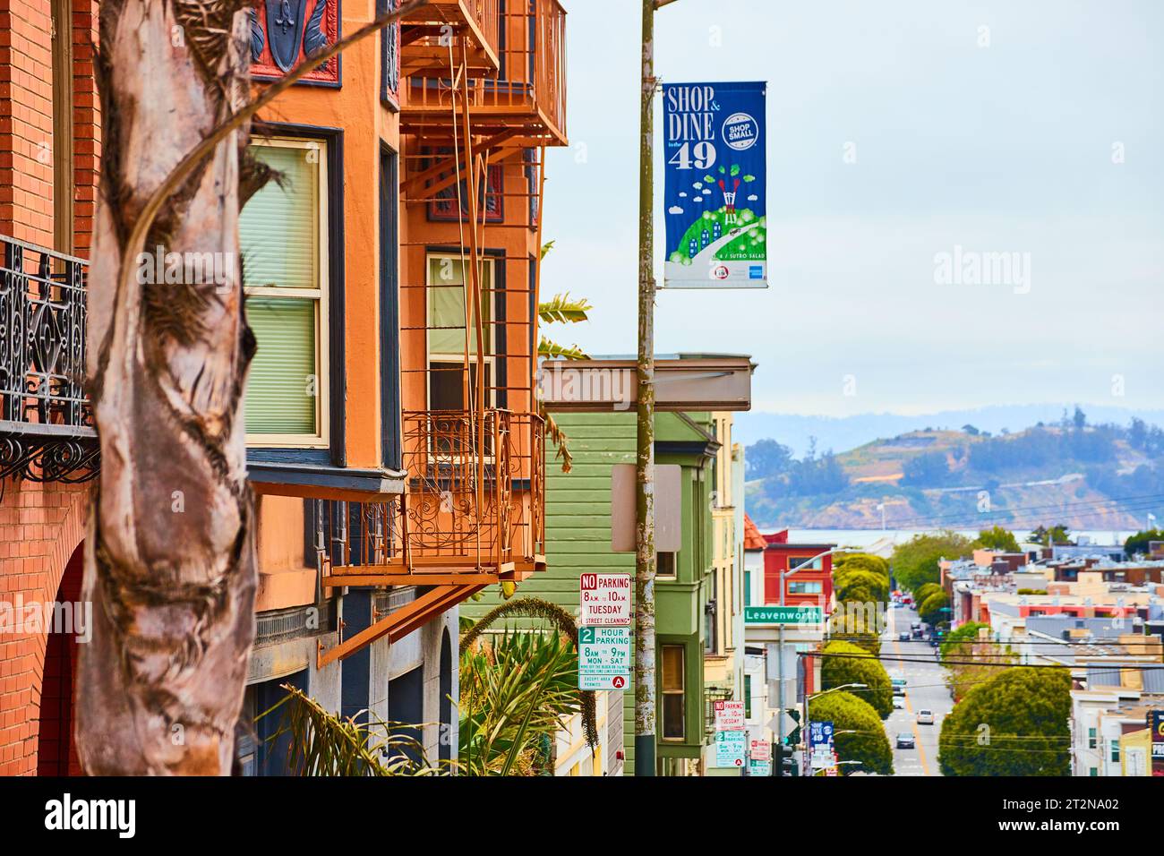 Street going down hill with colorful closely compact apartment ...