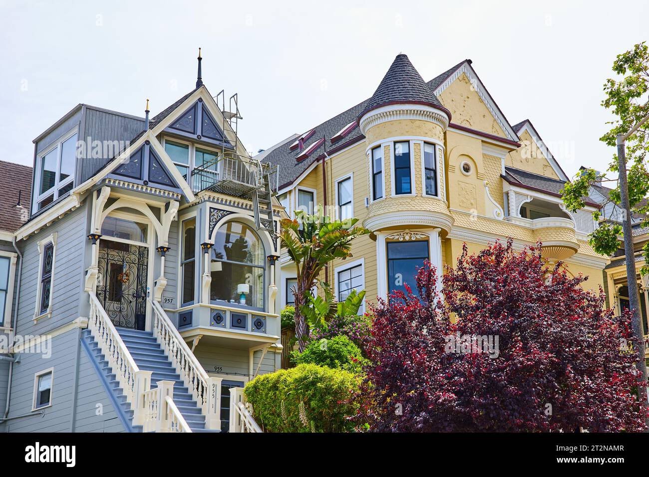 Castle tower on yellow house with large bay windows beside blue house ...