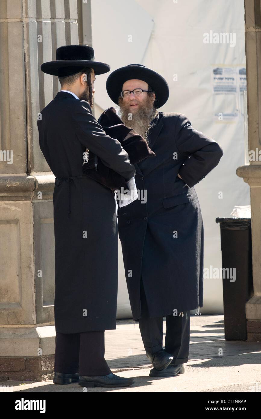 2 orthodox Jewish men have a conversation in front of a Satmar ...