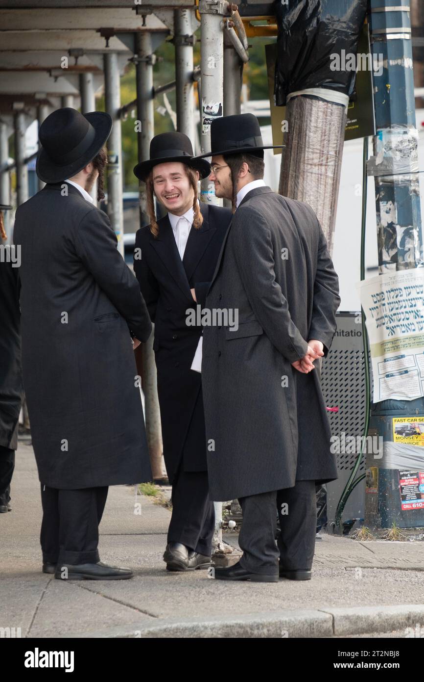 Three Hasidic Jewish men with long curled peyus have a fun conversation ...